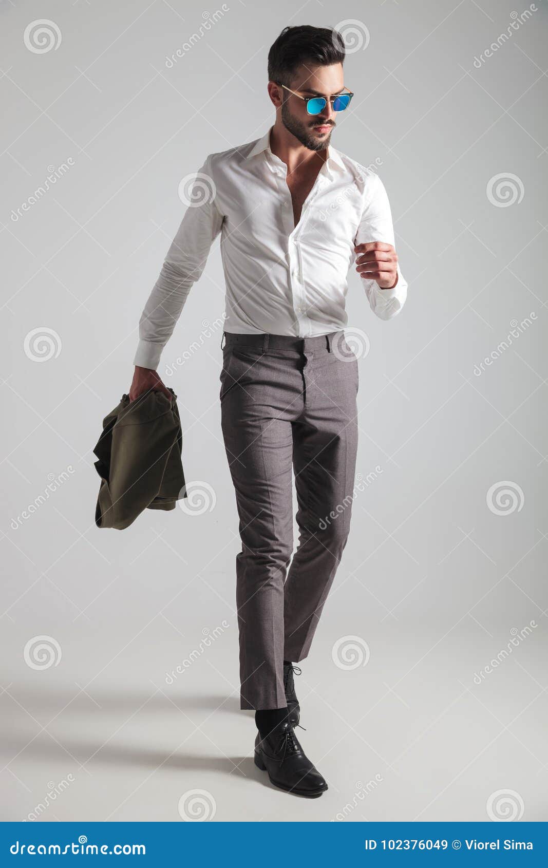 Side View of Walking Hipster Holding Coat and Looking Down Stock Image ...