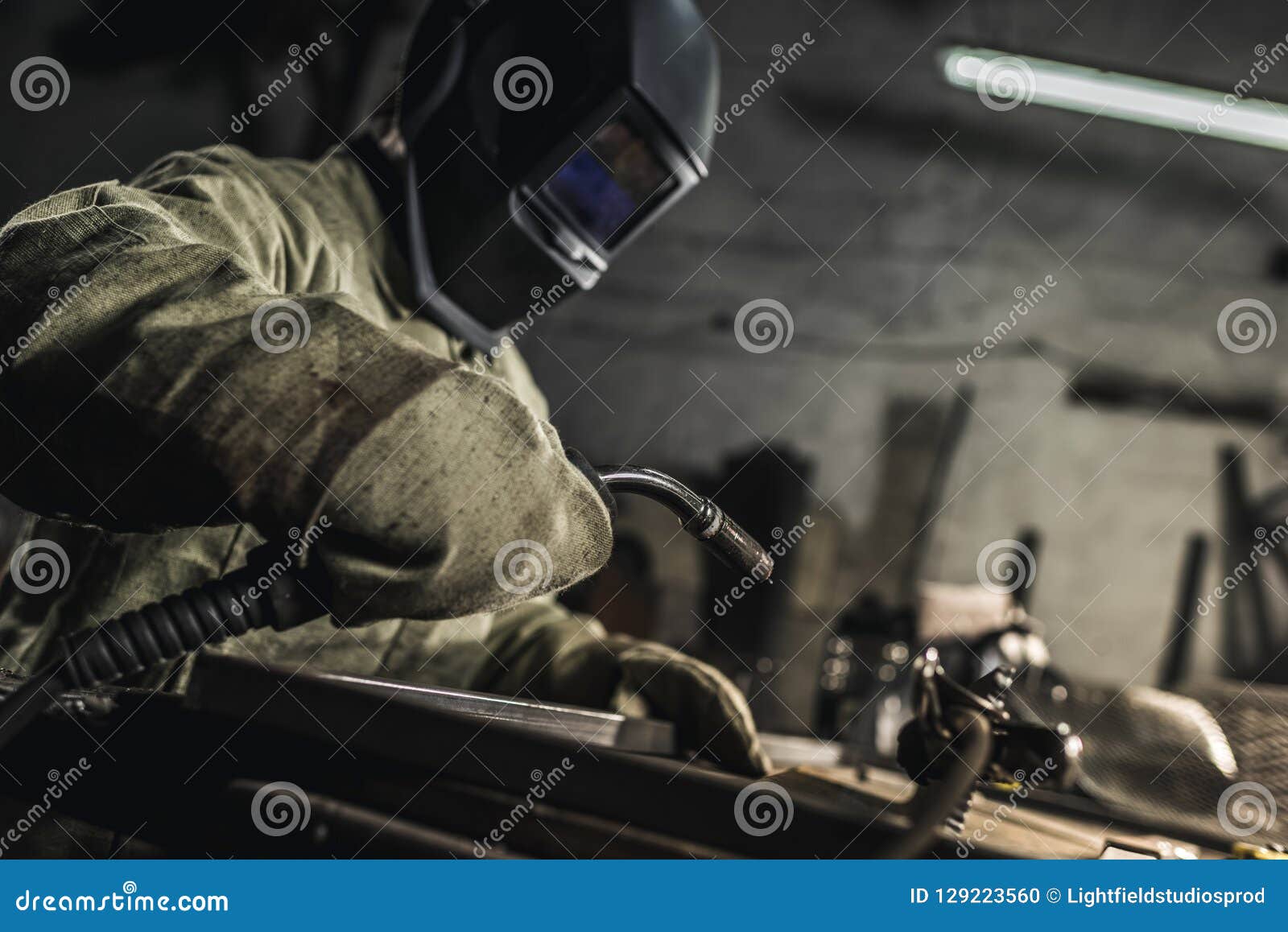 Side View of Welder in Protective Work Wear Working with Welding Torch ...