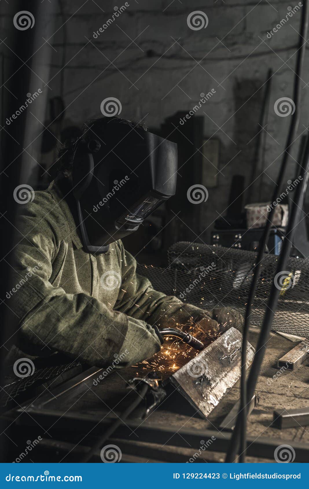 Side View of Welder in Protective Work Wear Working with Welding Torch ...