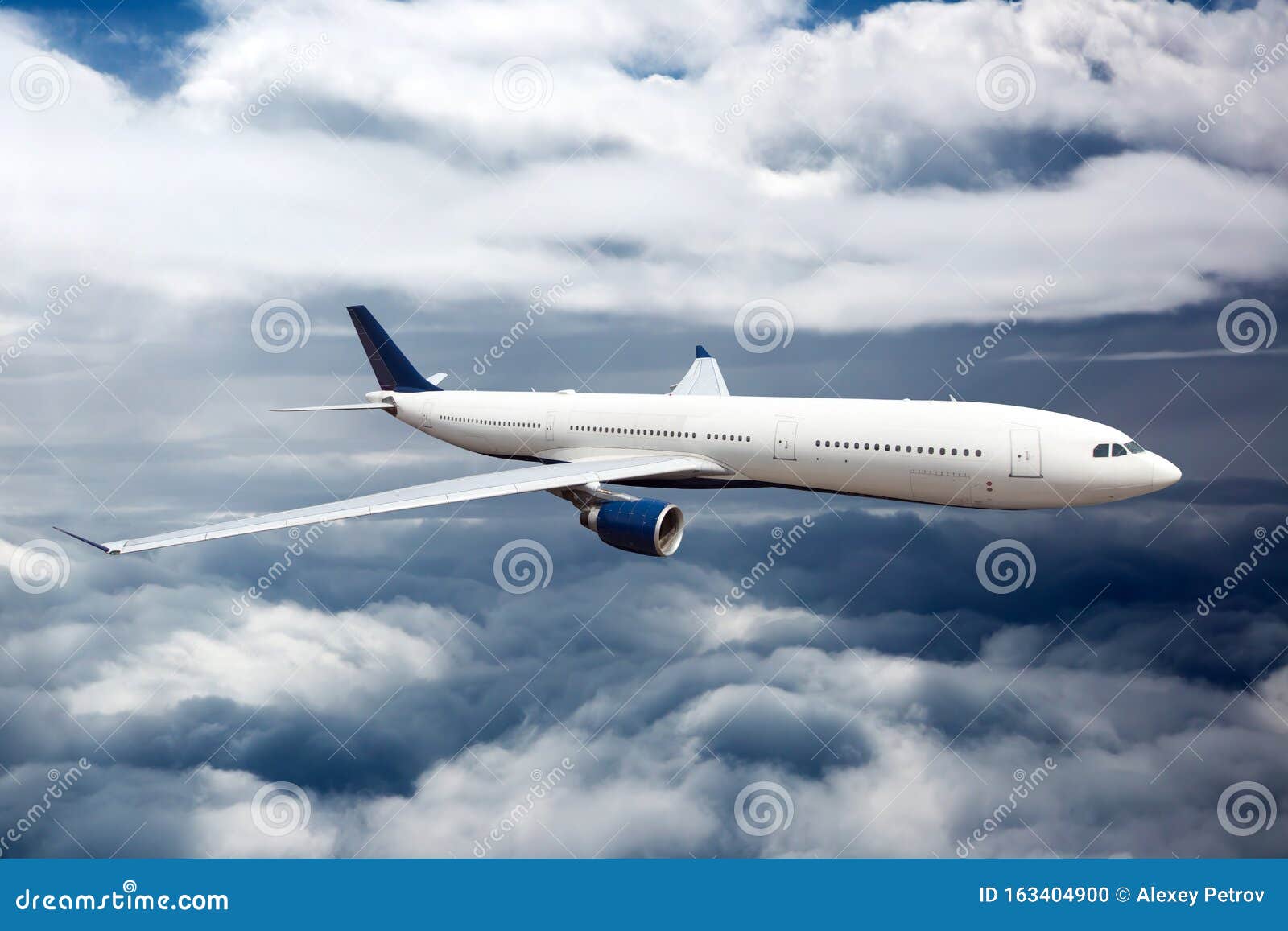 The Passenger Plane Flies High between the Clouds Layers Stock Photo ...