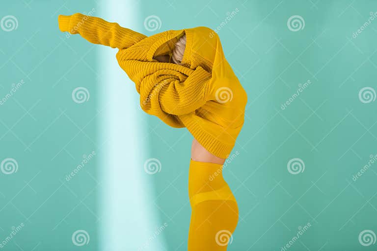 Side View Of Woman In Yellow Tights Wearing Yellow Sweater Posing Stock