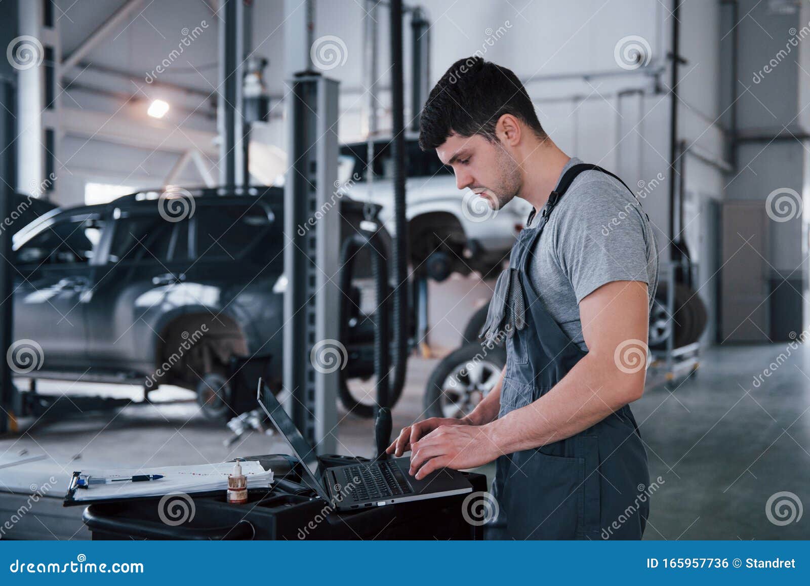 Side View. Worker Stands Indoors in Uniform Does Reports, Calculations ...
