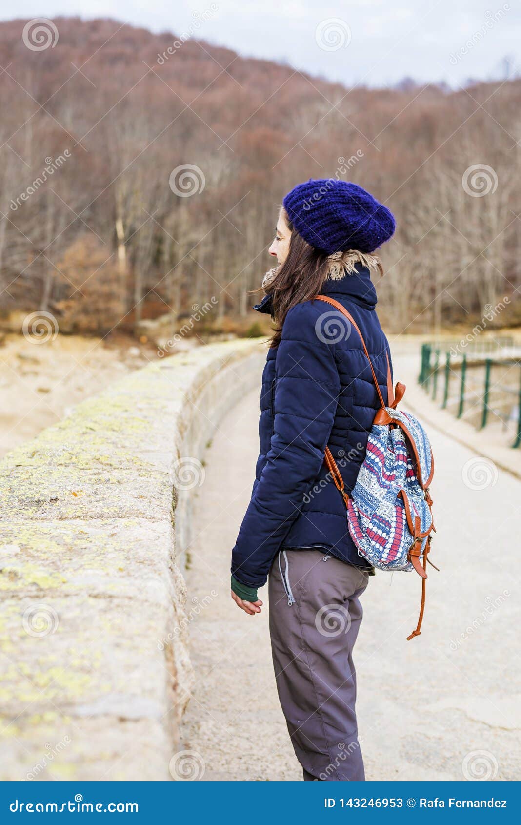 Side View of a Young Backpacker Woman Standing while Looking Away in ...
