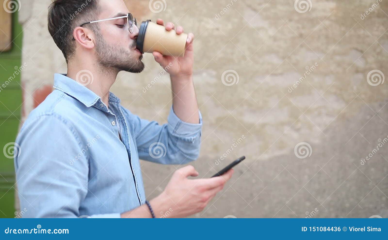 Side View of a Young Casual Man Drinking Coffee while Using Phone Stock ...