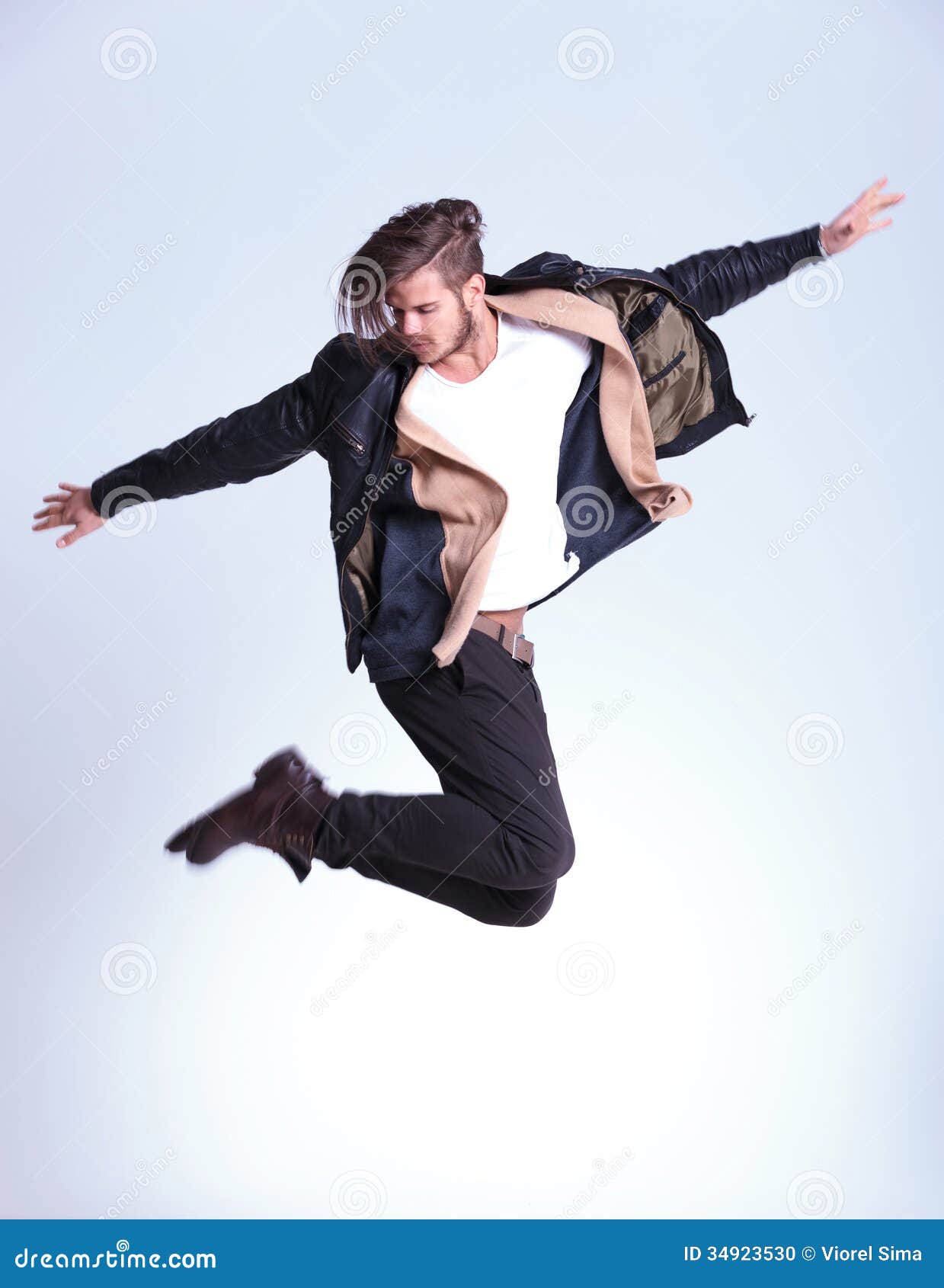 Side View of a Young Fashion Man in Leather Jacket Jumping Stock Photo ...