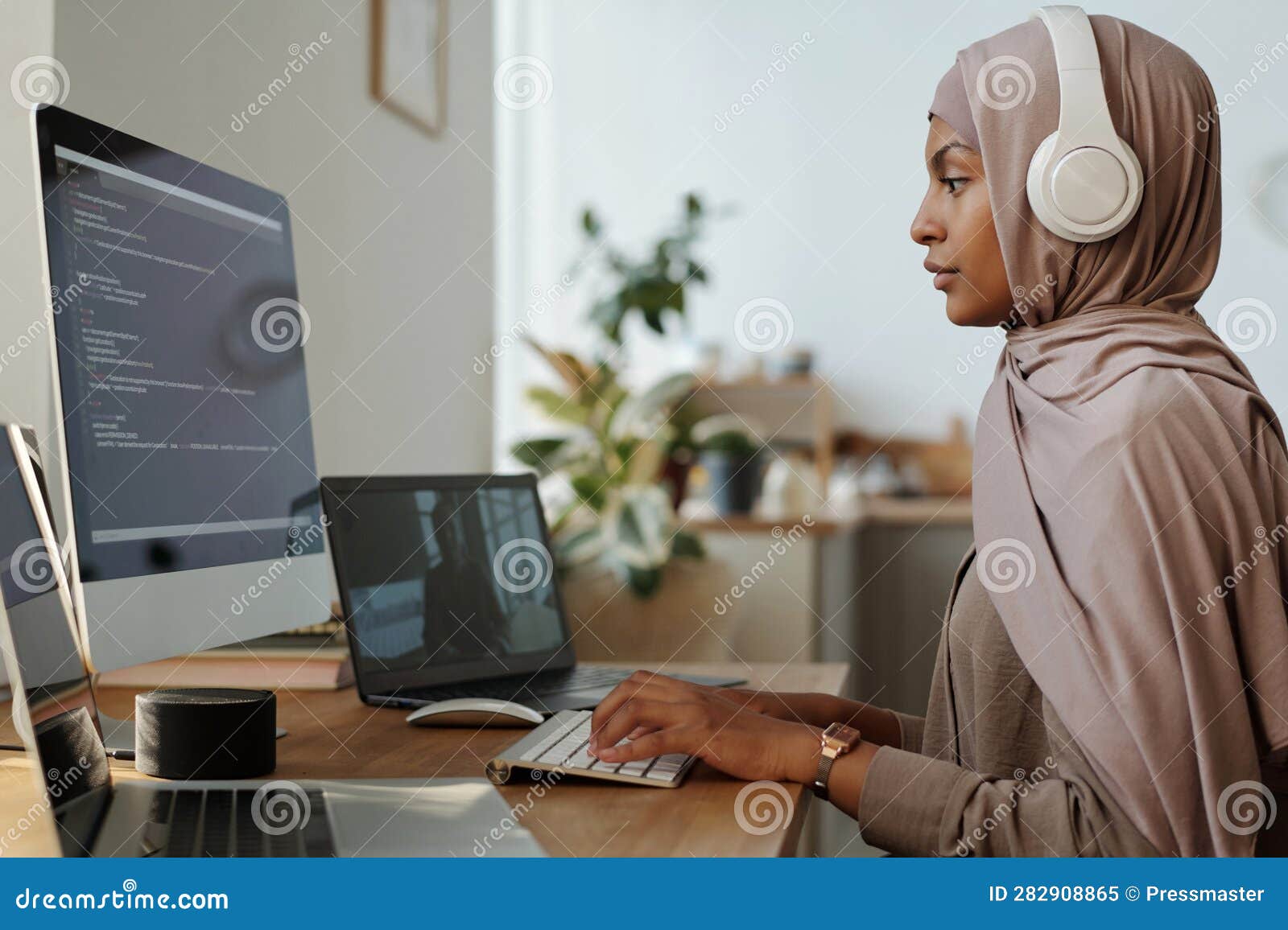 Side View of Young Female Programmer in Headphones and Hijab Stock ... Side View of Young Female Programmer in Headphones and Hijab Stock ...
