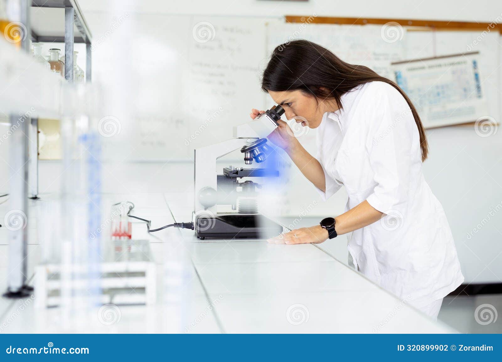 Side View of Young Female Scientist Looking through Microscope. Stock ...