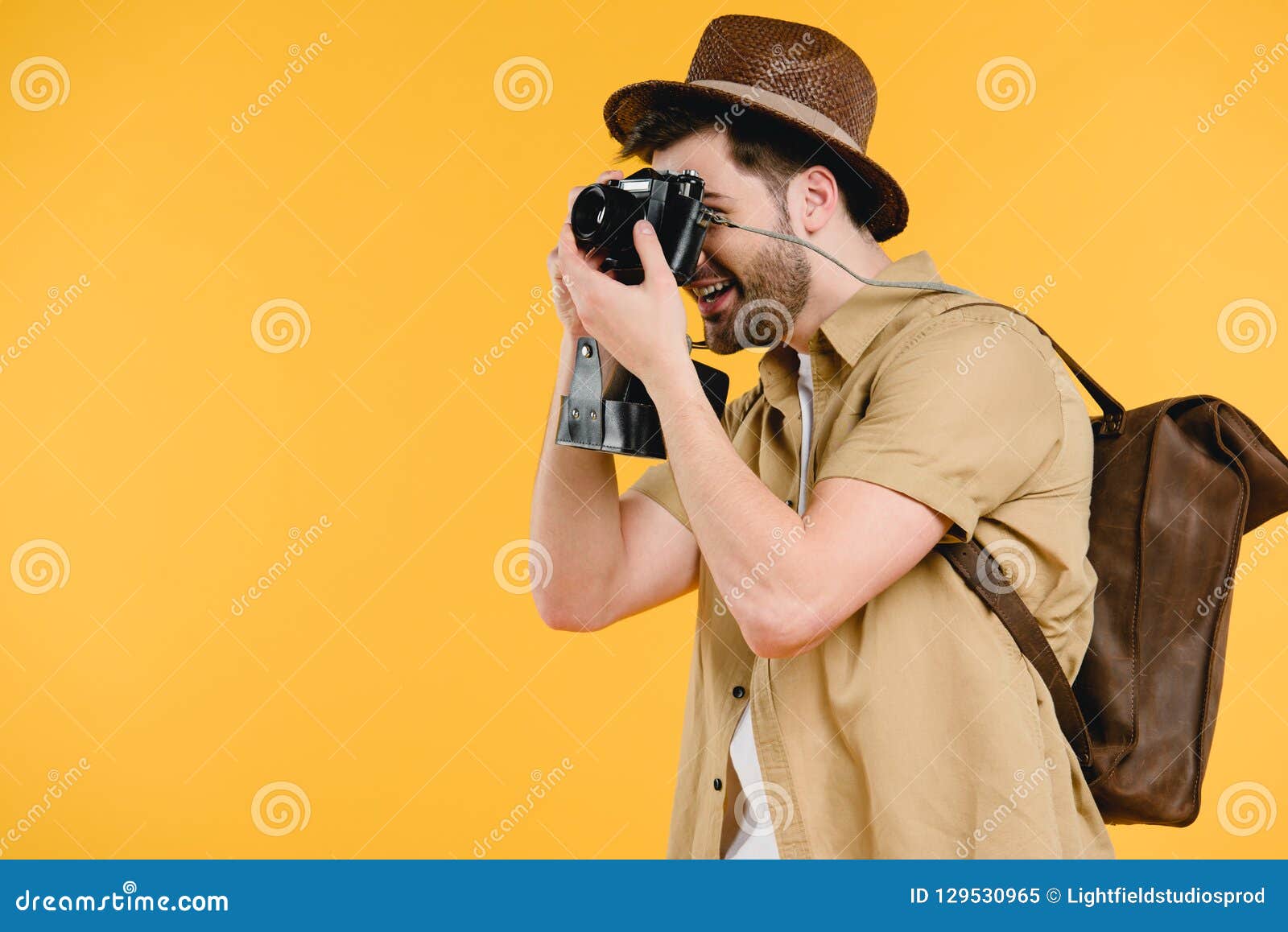 Side View of Young Man in Hat with Backpack Photographing with Camera ...