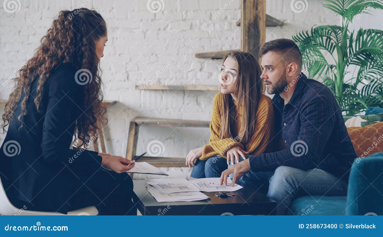 Side View of Young People Real Estate Agent and Buyers Looking at House ... Side View of Young People Real Estate Agent and Buyers Looking at House ...