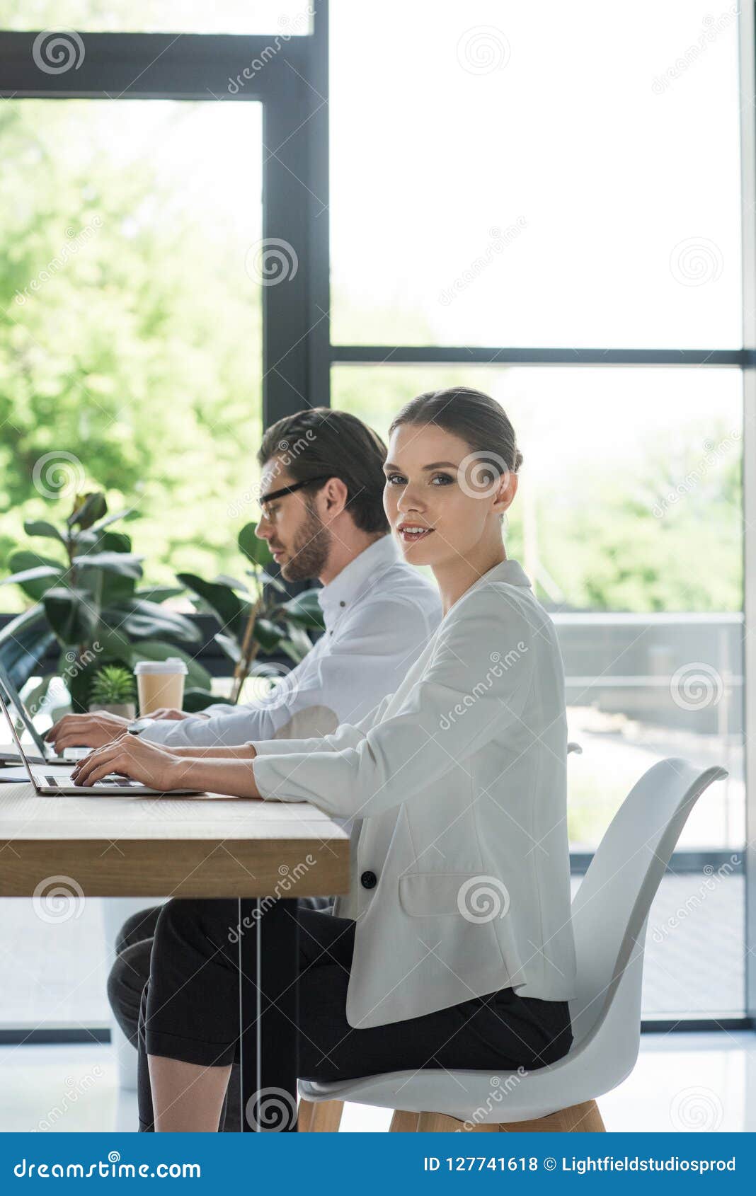 Side View of Young Successful Managers Working with Laptops Together ...