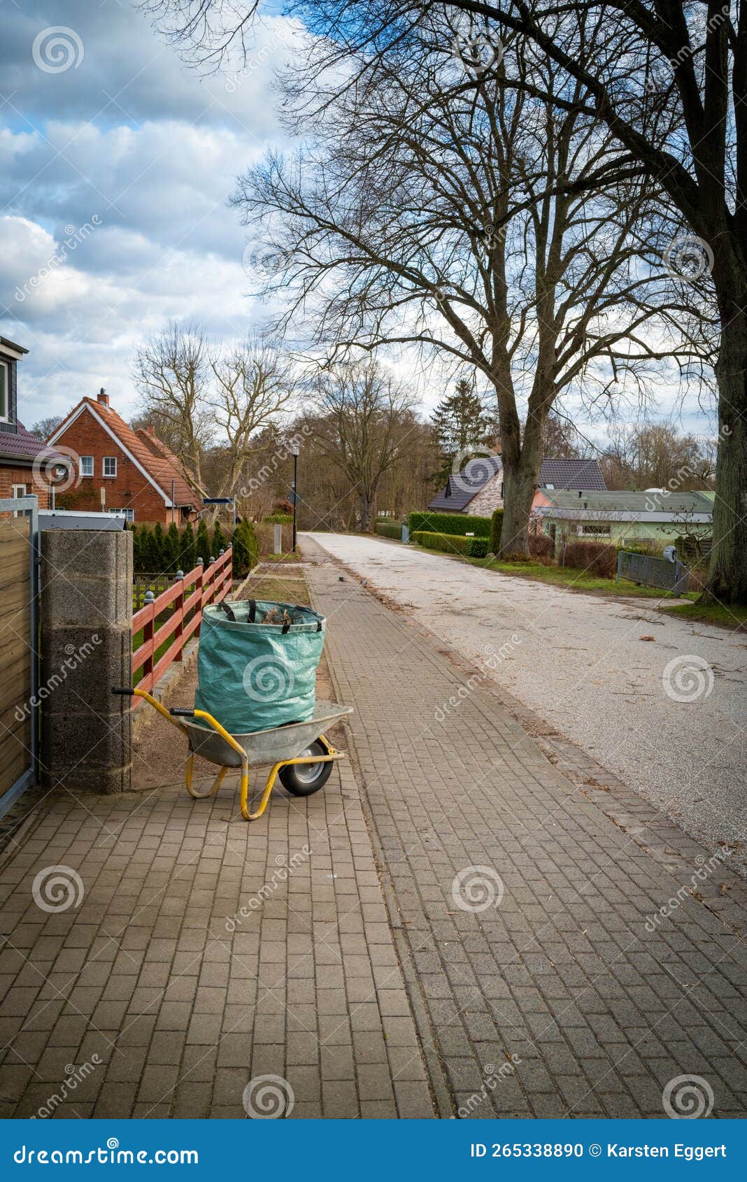 On the Sidewalk is a Wheelbarrow with a Garbage Bag on it Stock Photo ...