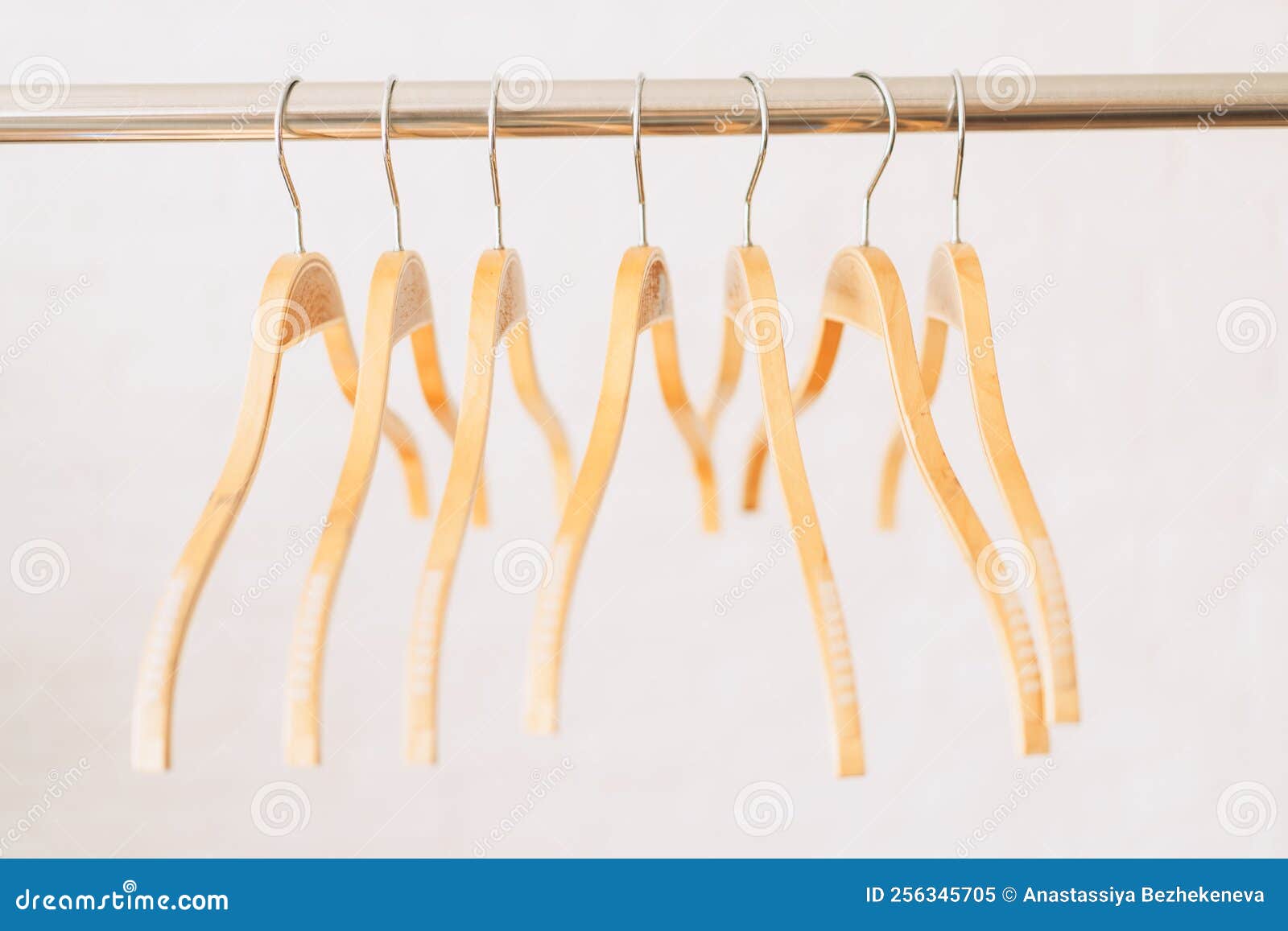 Siete Perchas De Madera En Una Barra De Hierro Imagen de archivo - Imagen de compras, fondo ...