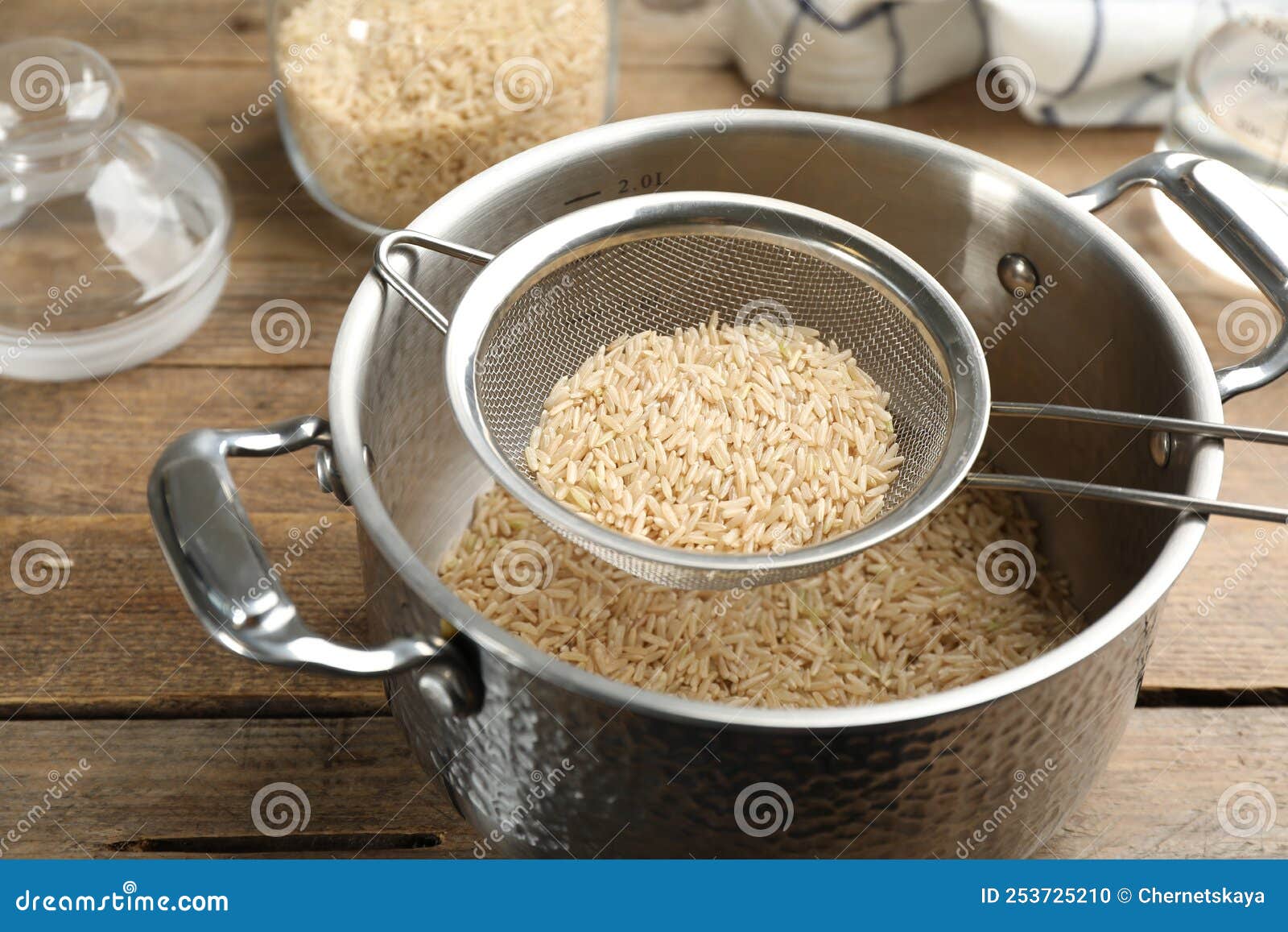 Sieve with Rice in Pot on Wooden Table, Closeup Stock Photo - Image of ...
