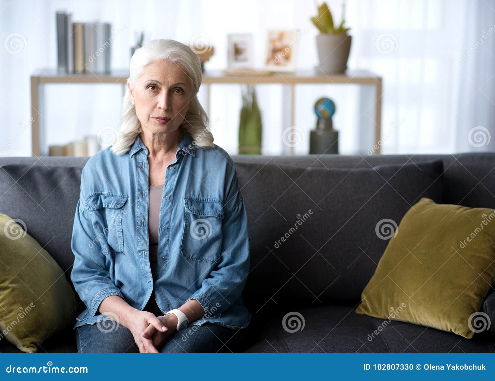 Signora Matura Seria Che Individua Sullo Strato A Casa Fotografia Stock Immagine Di Sguardo