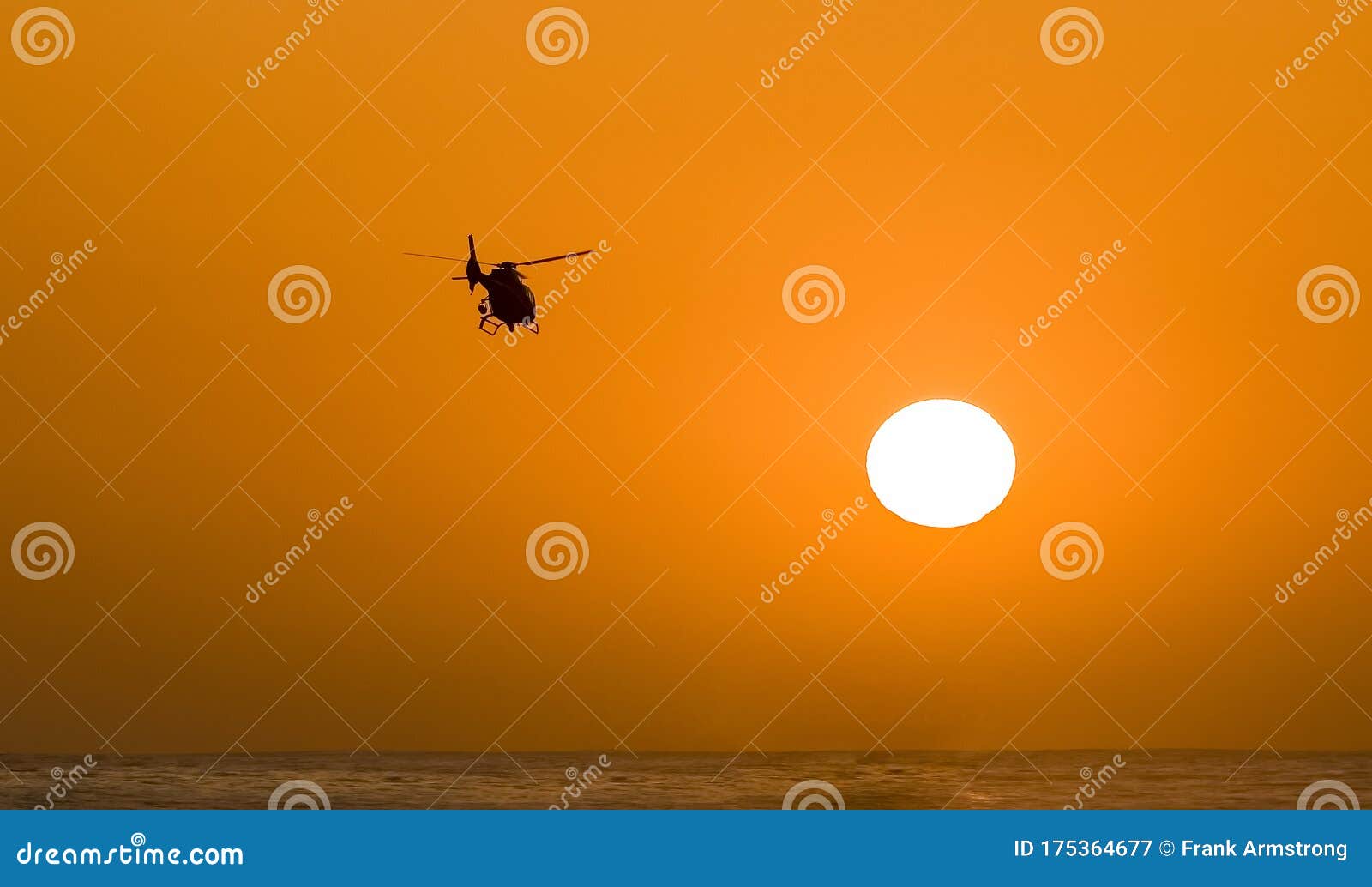 Sihouette of Helicopter Headed Toward Setting Sun Over Water Stock ...