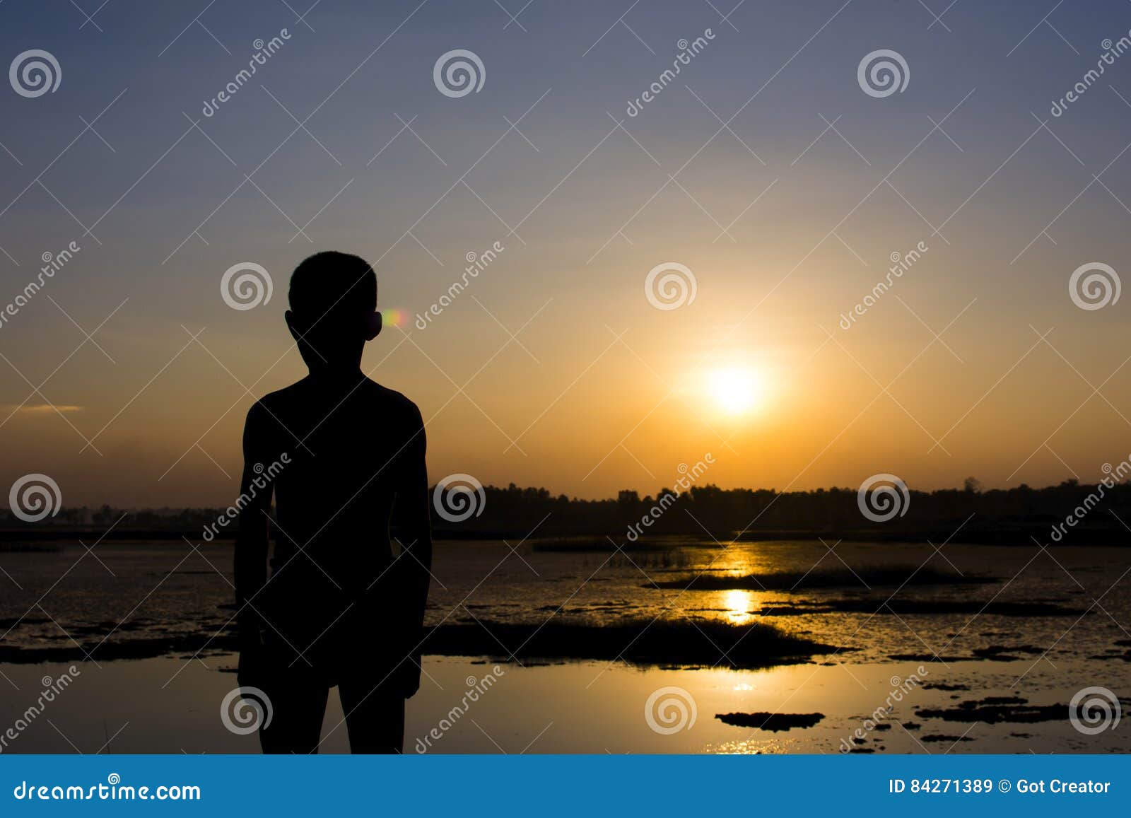 Silhouette of the Boy Stand Watching the Sunset on the River Stock ...