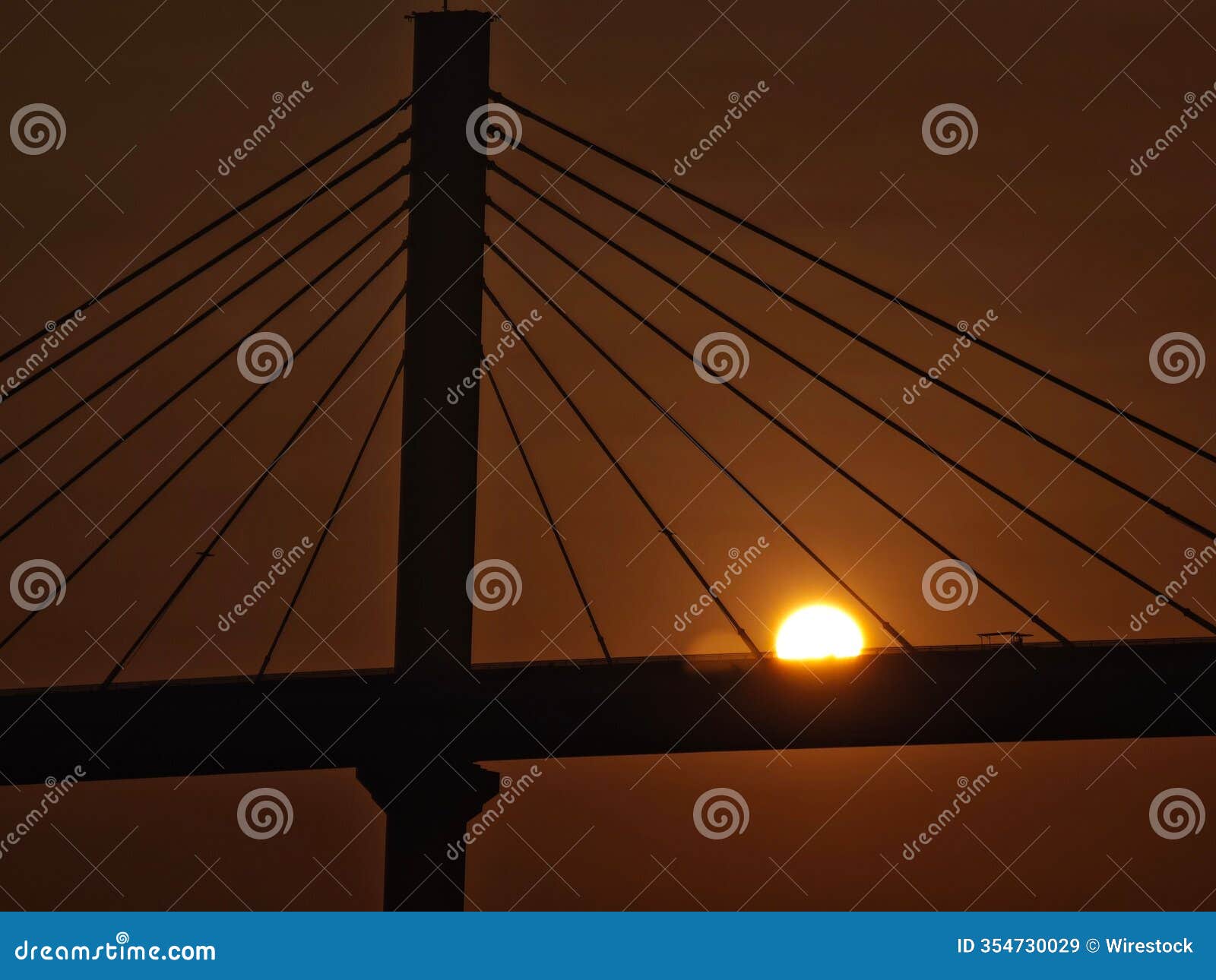 Silhouette Of A Cable-stayed Bridge At Sunset, With The Sun Setting ...