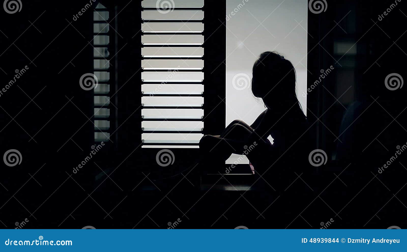 Silhouette of a Child Who is Sitting on the Sill and Looking Out the ...
