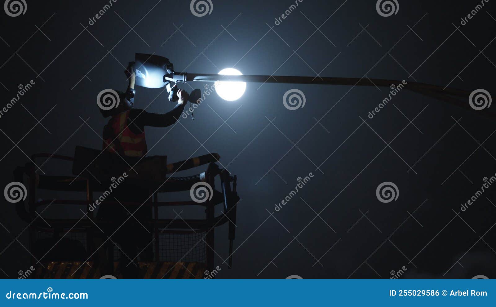 Silhouette of a Electric Engineer Working on a Street Lamp with the ...