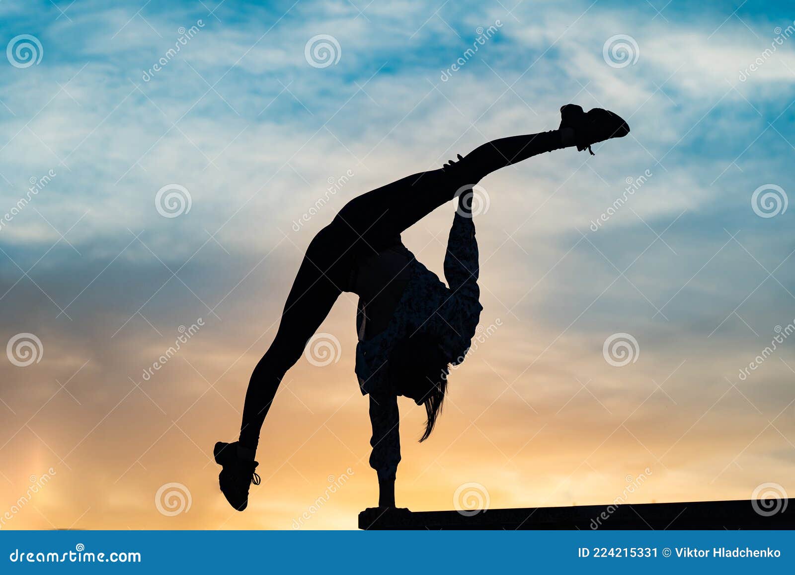 Silhouette of Female Flexible Acrobat Doing Handstand on the Dramatic ...