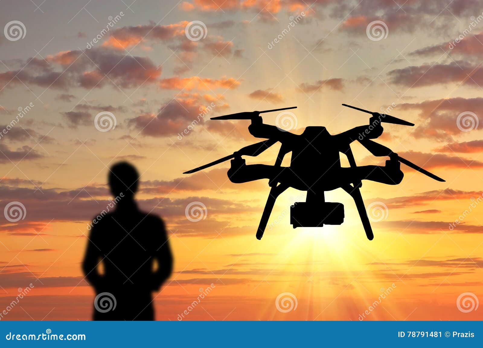Silhouette of a Flying Drone, and a Man with a Remote Control at Sunset ...