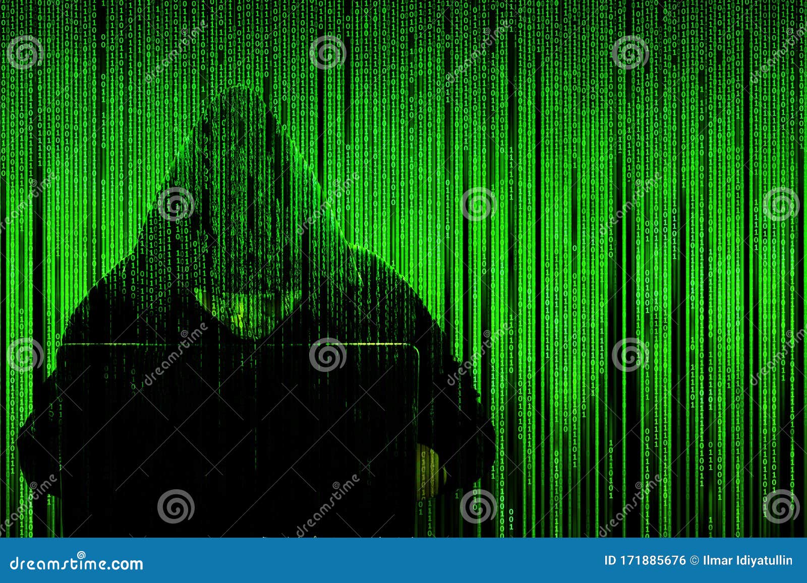 Silhouette Of A Hacker In A Hood With A Laptop On A Background Of A Matrix Of Binary Computer