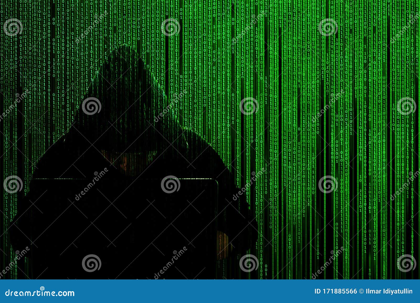 Silhouette Of A Hacker In A Hood With A Laptop On A Background Of A Matrix Of Binary Computer