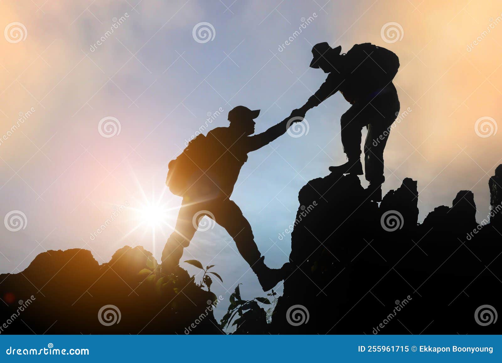 Silhouette Of Hiker Helping Each Other Hike Up A Mountain At Sunset ...