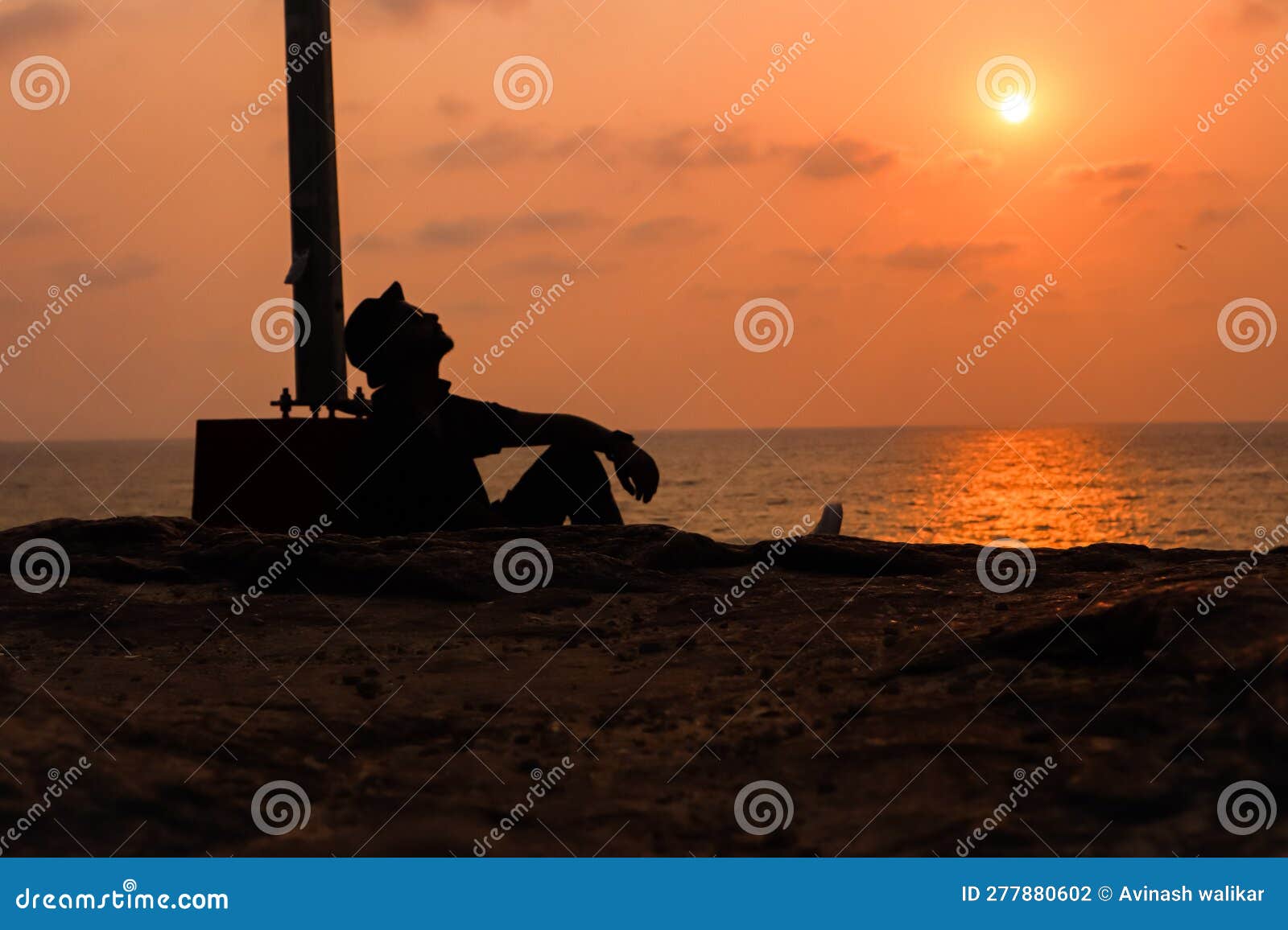 The Silhouette Image of a Sad Boy Sitting Near an Ocean with Sky in the ...