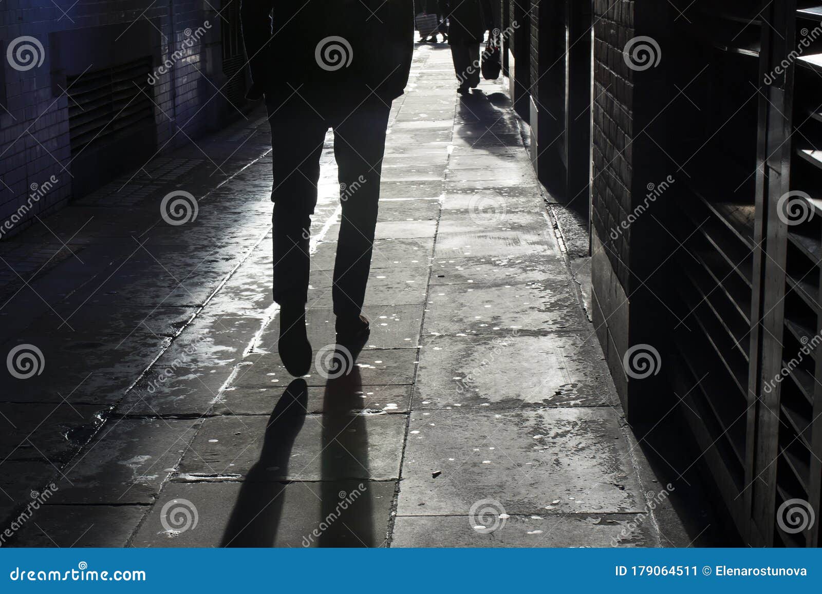 Silhouette of a Man in Backlight Walking Down the Street in the Setting ...