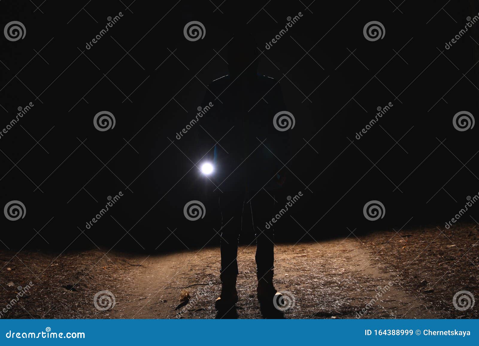 Silhouette Of A Man With Flashlight On His Head Pointing Bright Beam Of ...
