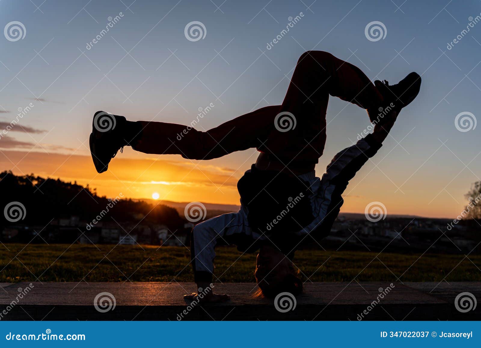 Silhouette of a Man Doing a Breakdance Position in Front of a Sunset ...