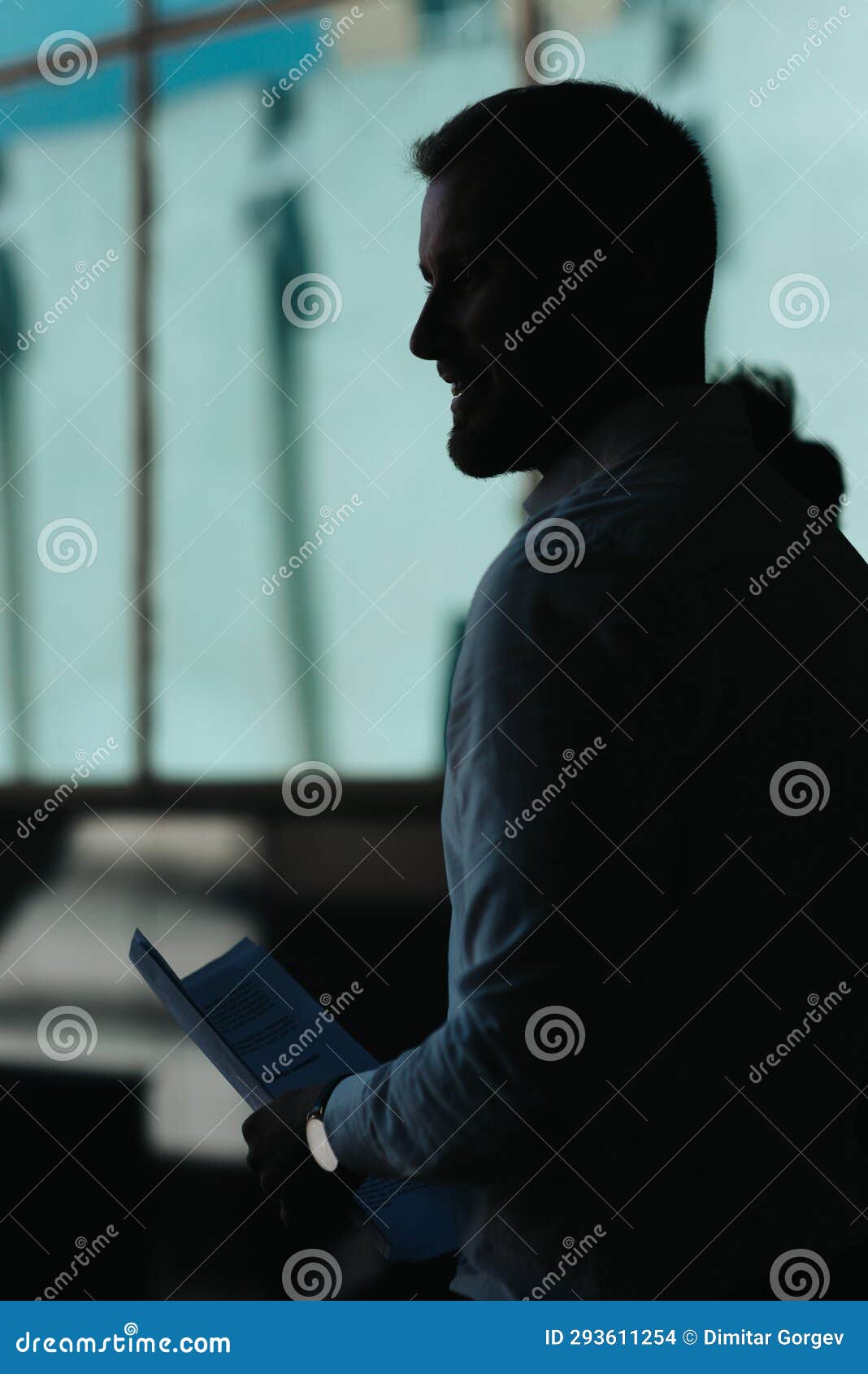 Silhouette of Man Holding Paperwork Walking, Looking at Something and ...