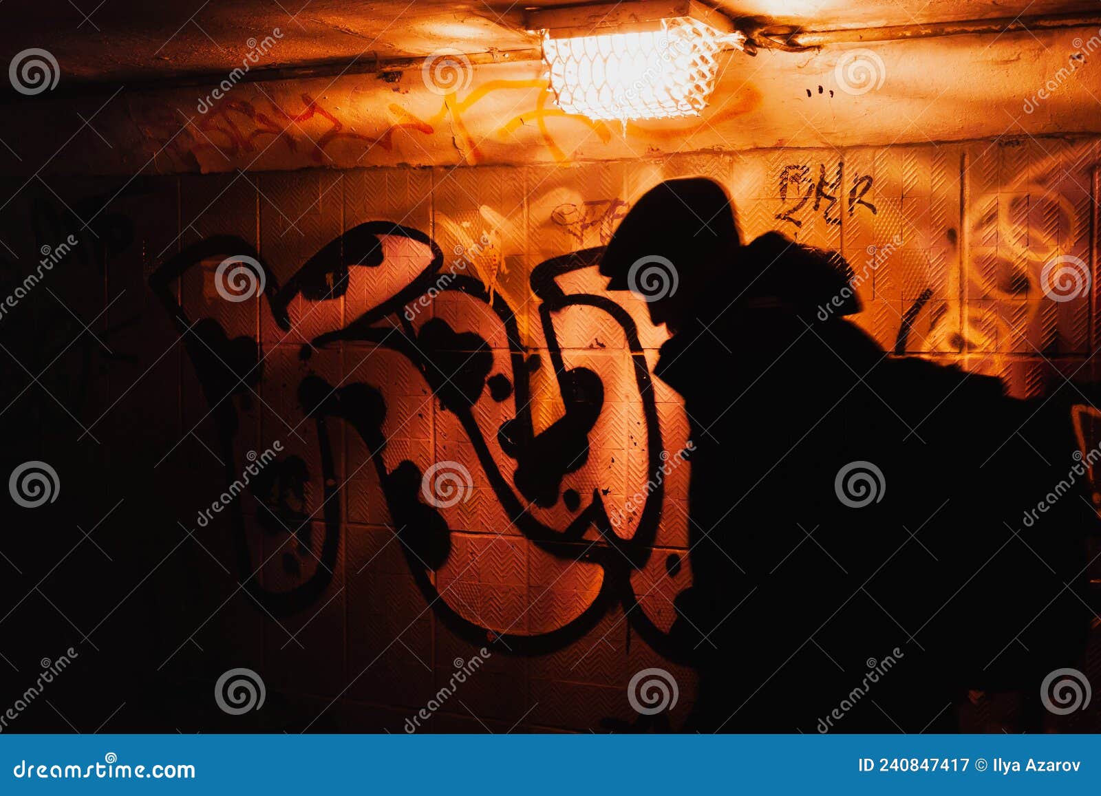 A Silhouette of a Man Passing in a Dark Red Rusty Tunnel with Dim ...