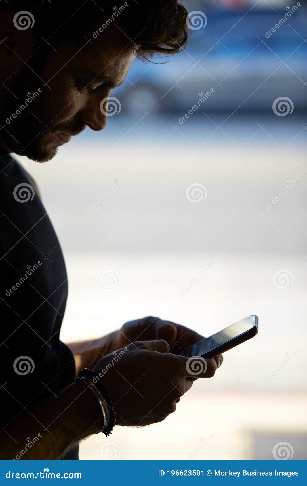 Silhouette of Man Texting on Mobile Phone Standing by Window Stock ...