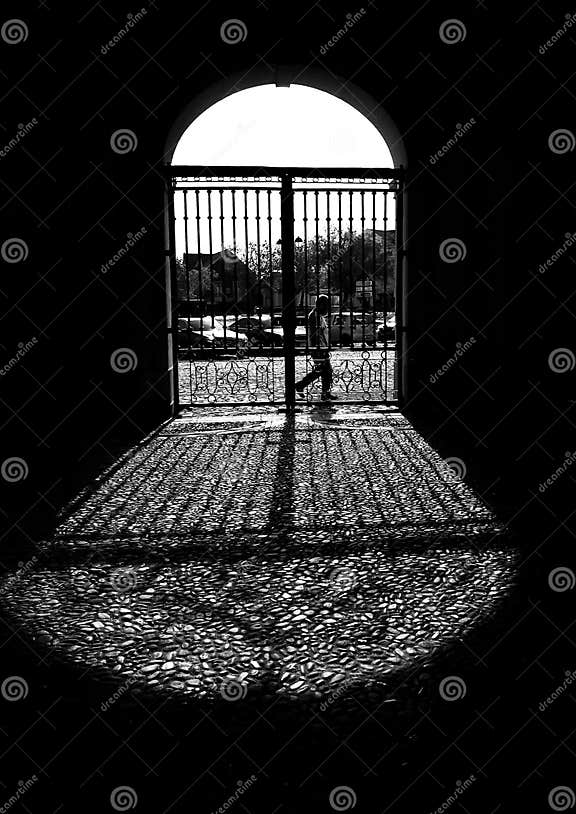 Silhouette of a Man Walking Behind a Gate Stock Image - Image of light ...