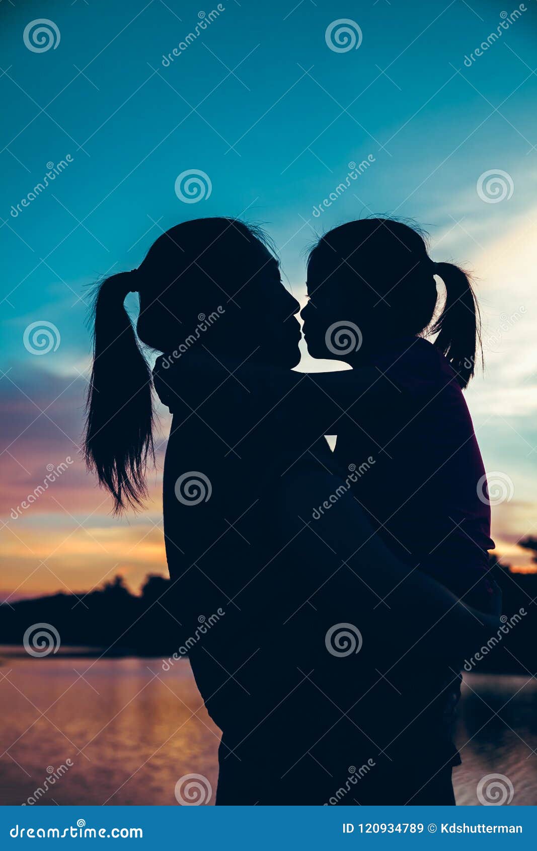 Silhouette Of Mother And Her Daughter Enjoying View At Riverside Stock