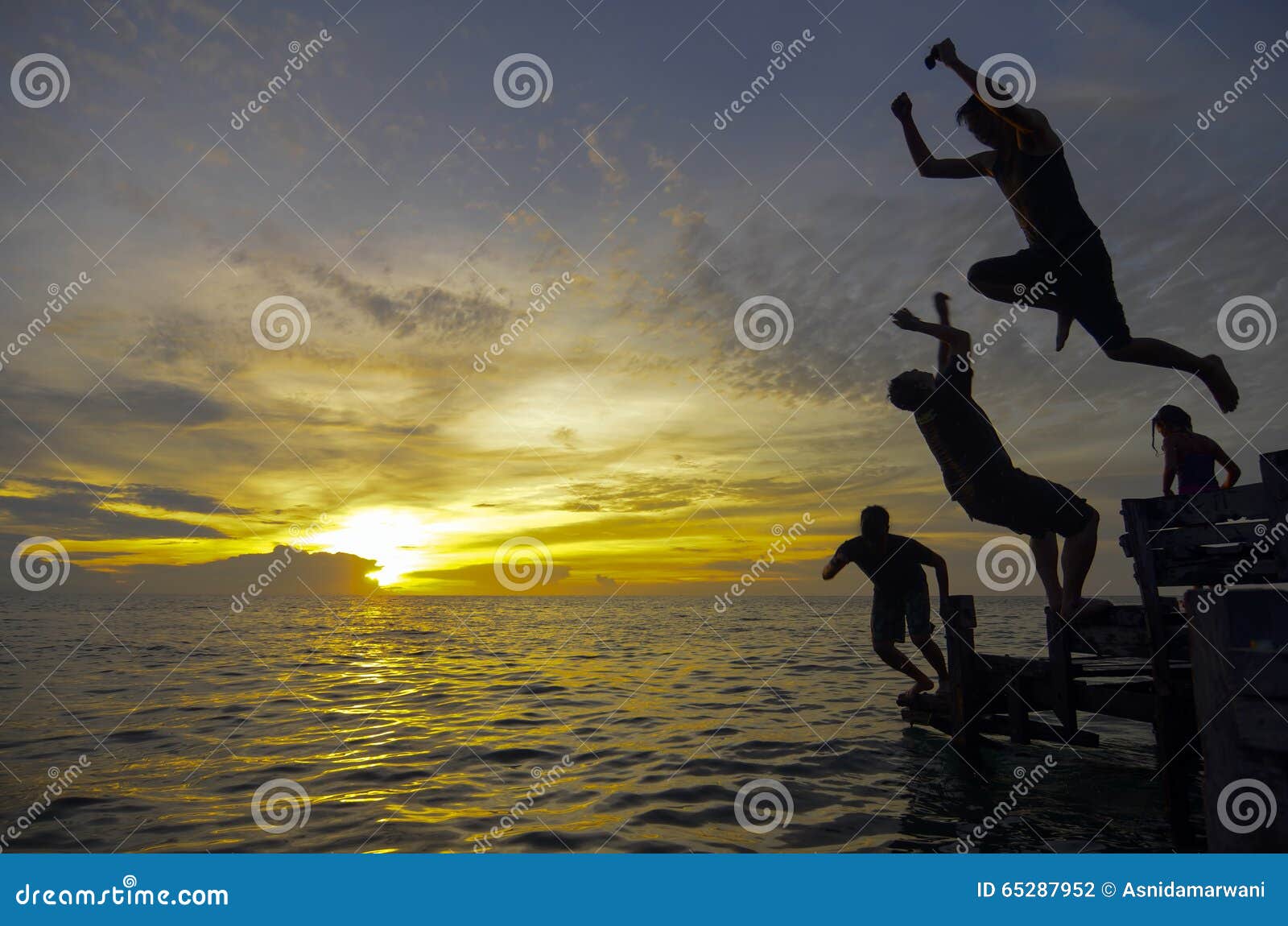 Silhouette of Three Young Man Jumping during Awesome Sunset Stock Photo ...