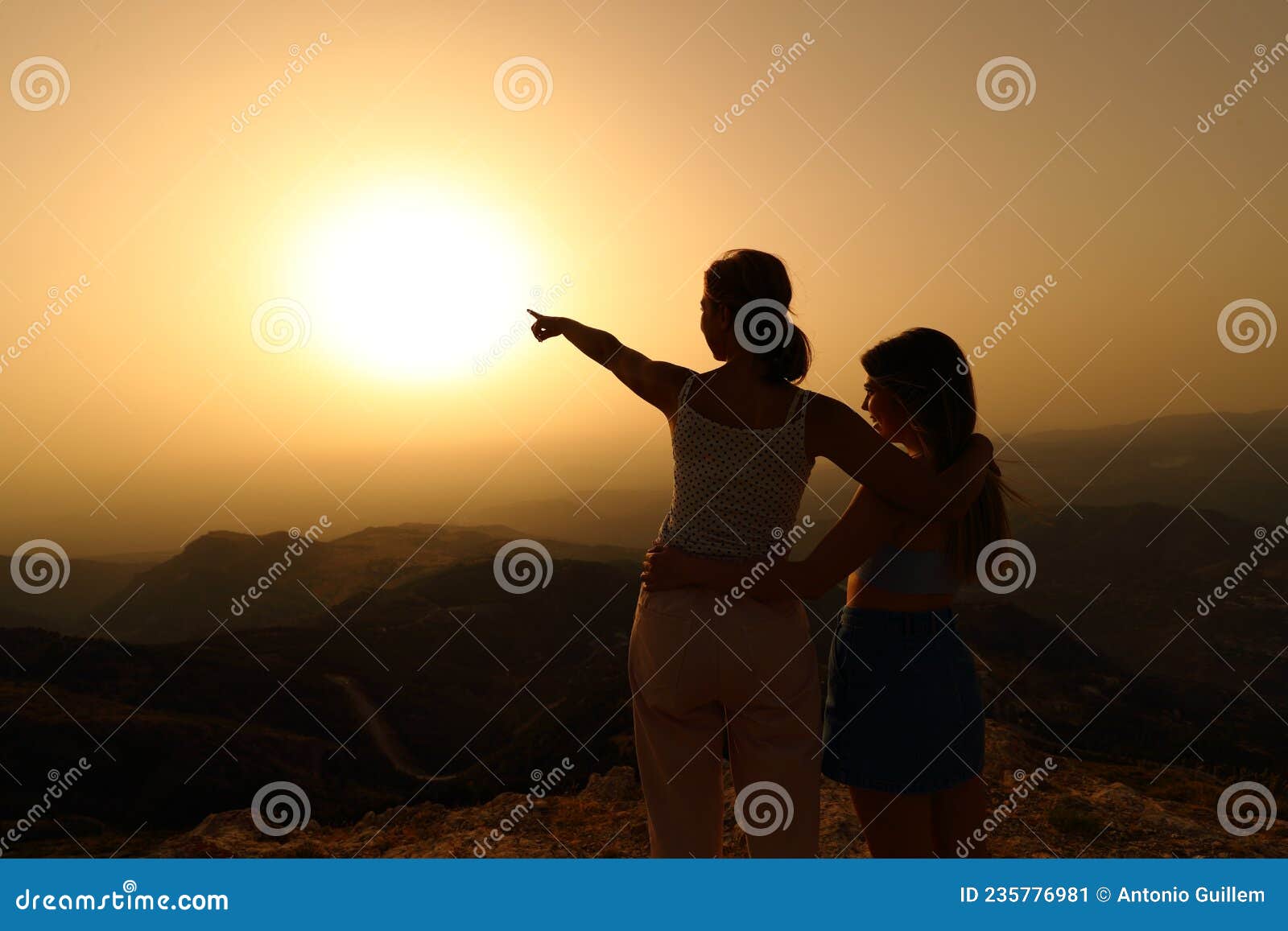 Silhouette of Two Women Pointing Sun at Sunset Stock Image - Image of ...