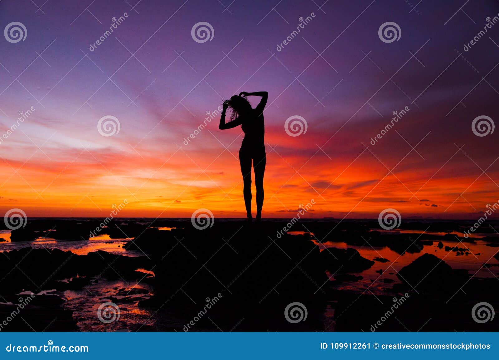 Silhouette Of Woman Standing On Rock Picture. Image: 109912261