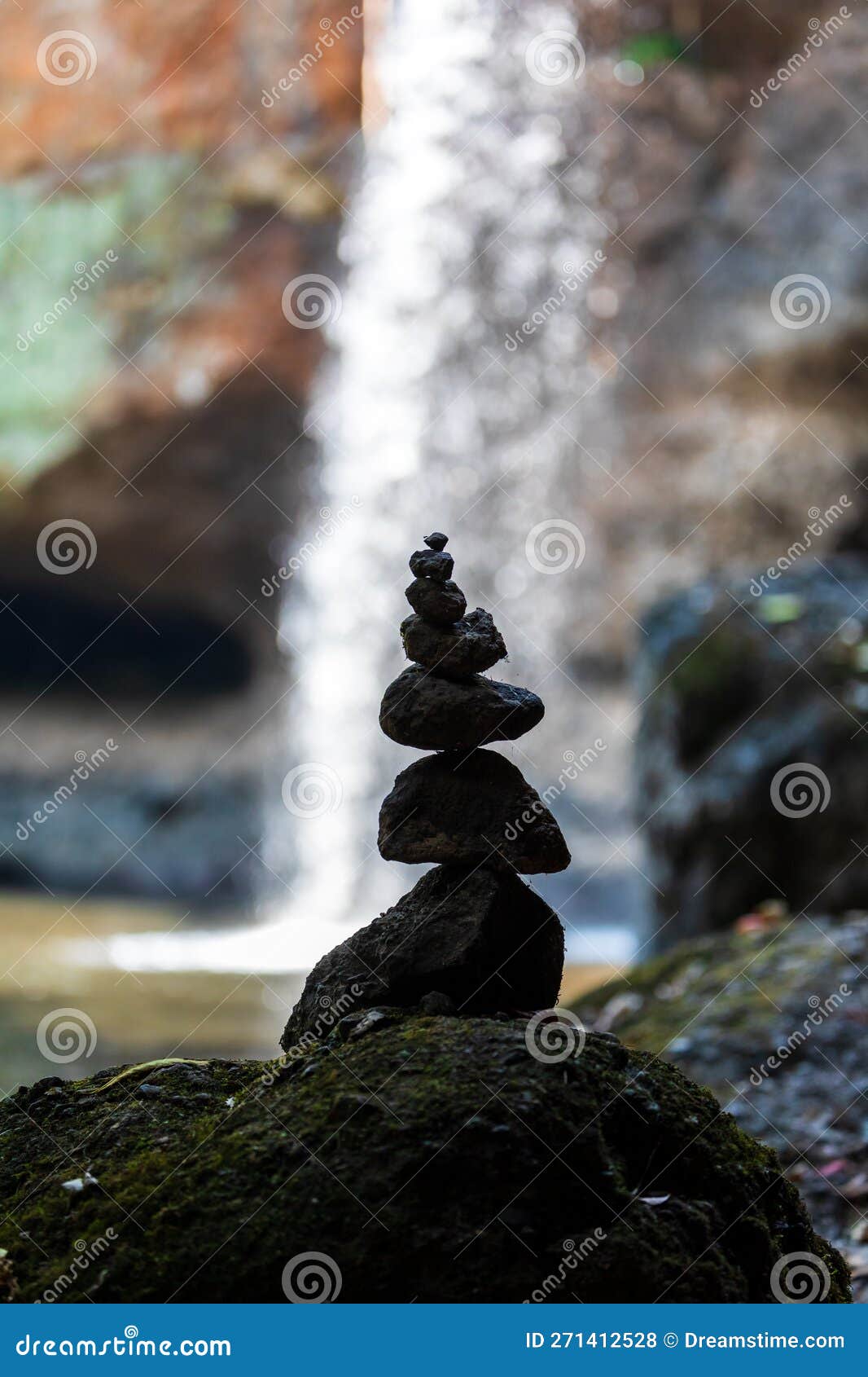 Silhouetted Cairn Stacked Stones with Blurry Background of Waterfall ...