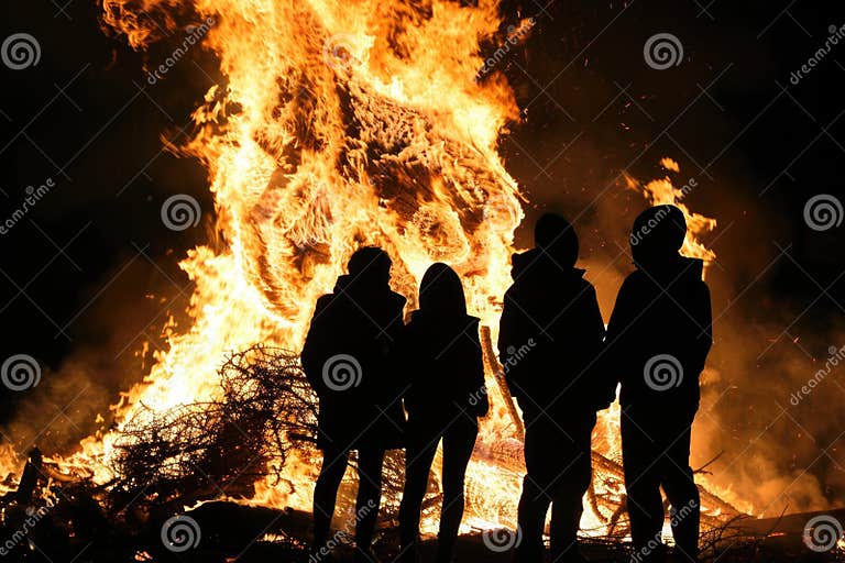 Silhouetted Figures Standing by a Massive Bonfire at Night Stock Image ...