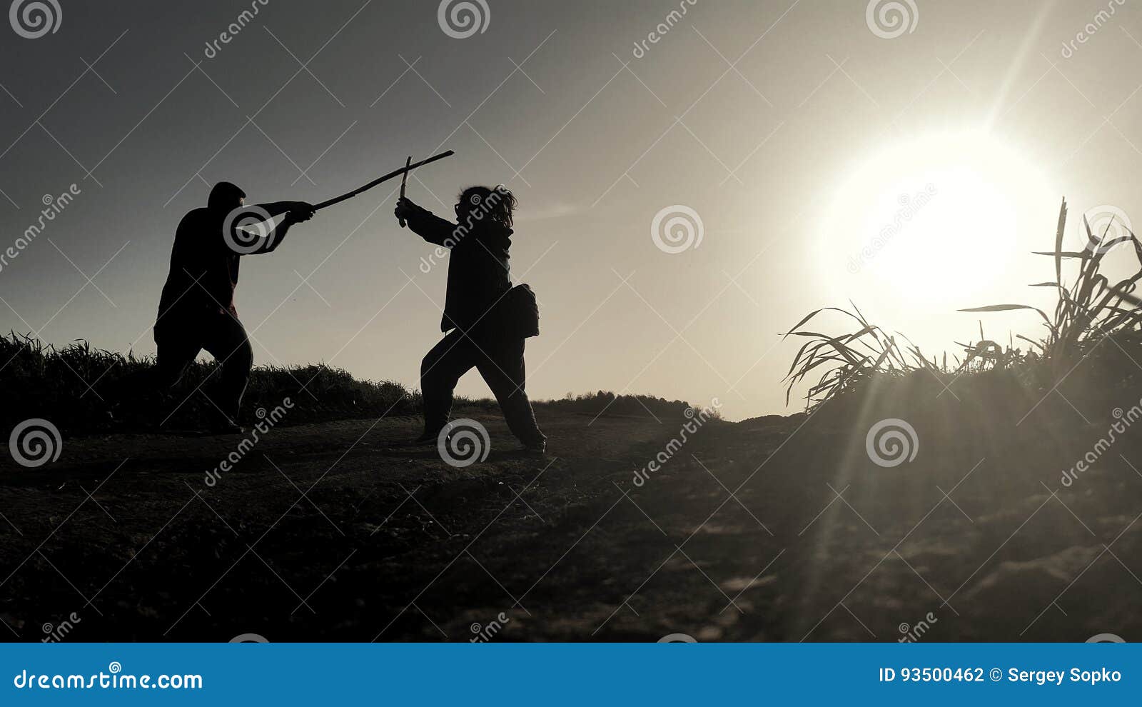 Silhouettes of Two Samurai Fighting with Swords in the Rays of Sunset ...