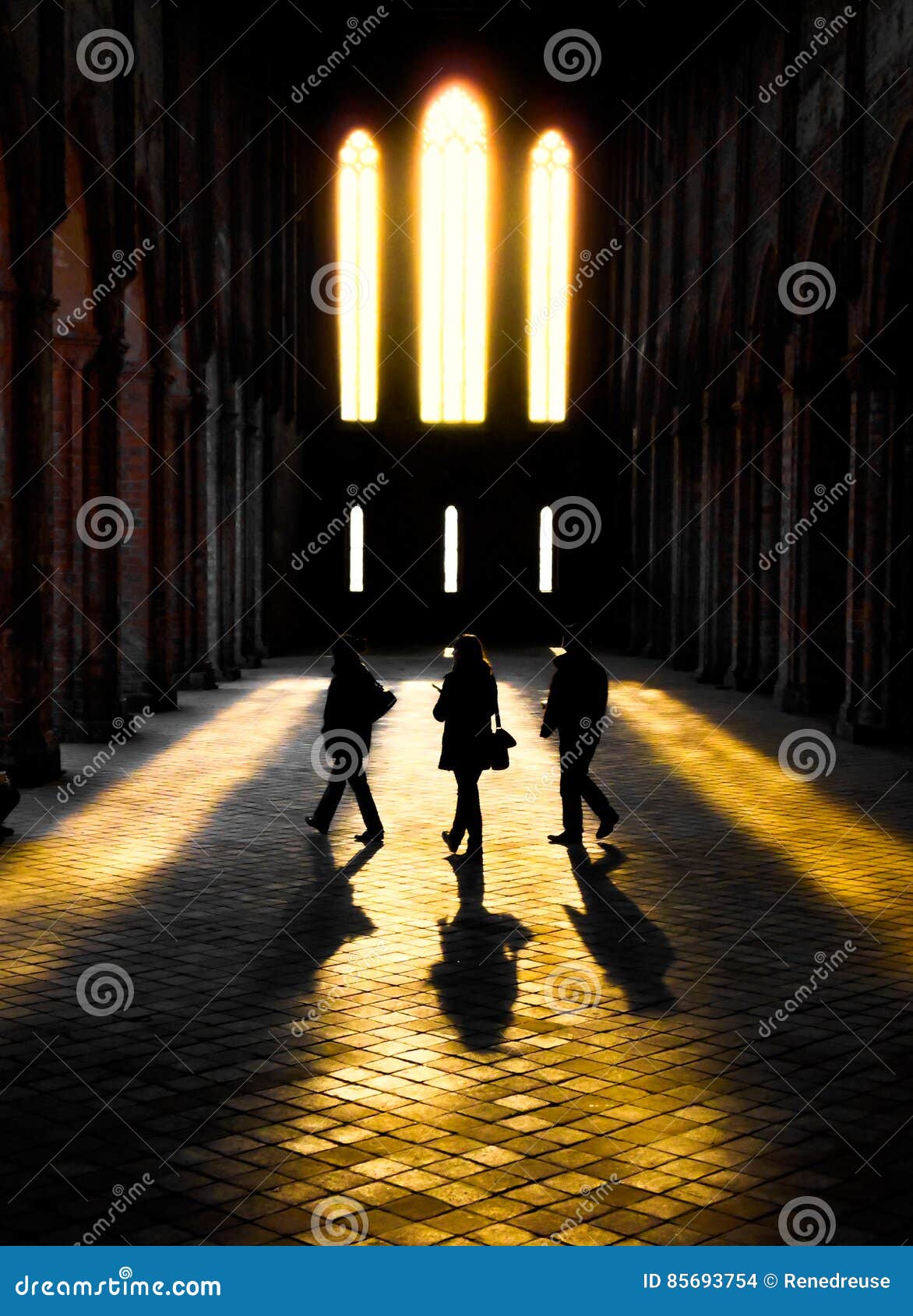 Silhouttes of Three People Walking through Sunlight in an Convent ...