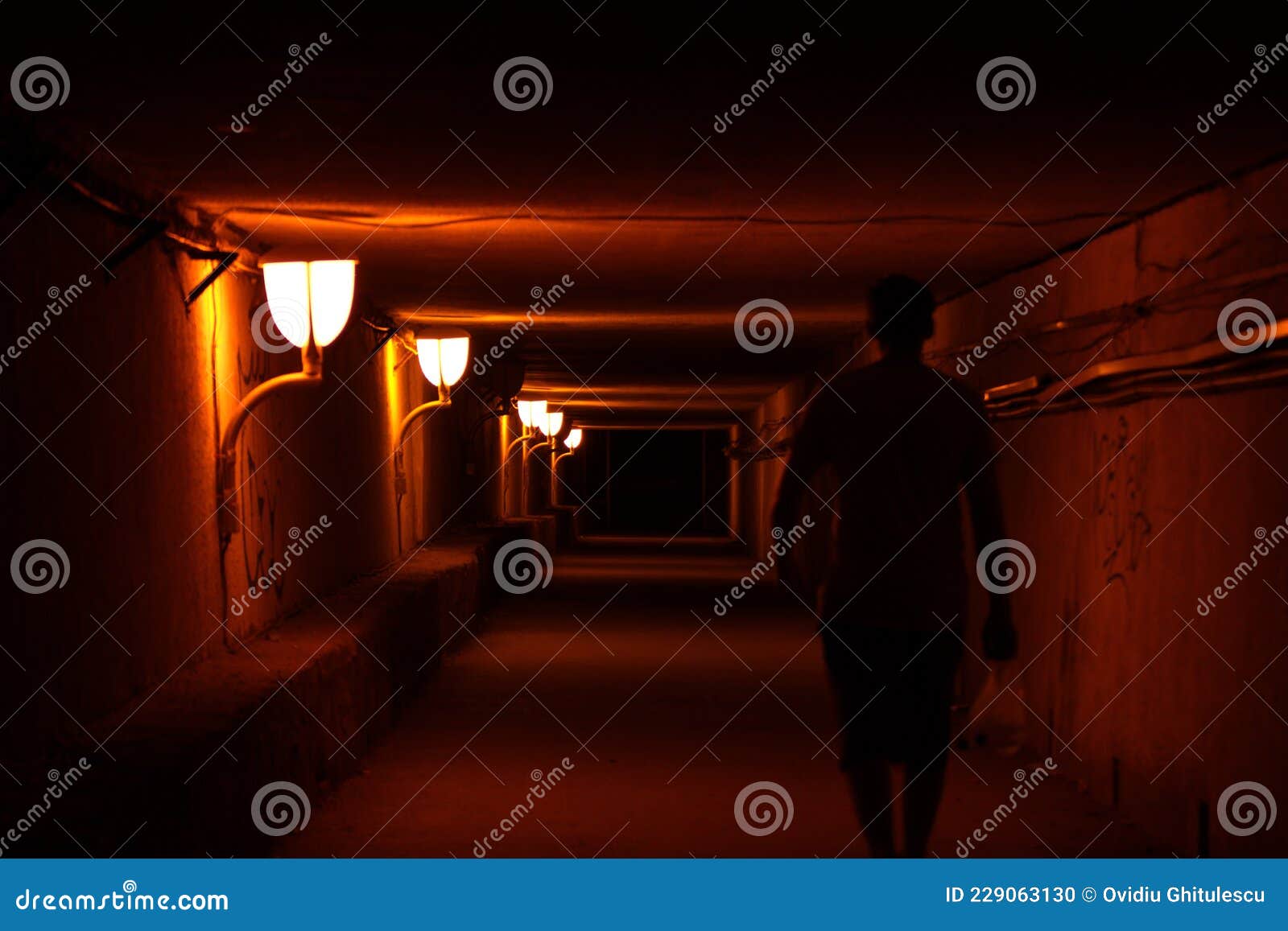 Silhueta De Um Homem Que Atravessa a Passagem Iluminada Por Lanternas ... Silhueta De Um Homem Que Atravessa a Passagem Iluminada Por Lanternas ...