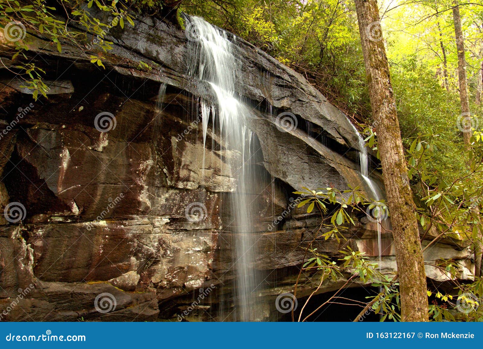 Silky Smooth Water Fall Flowing Down The Rocky Terrain Stock Image