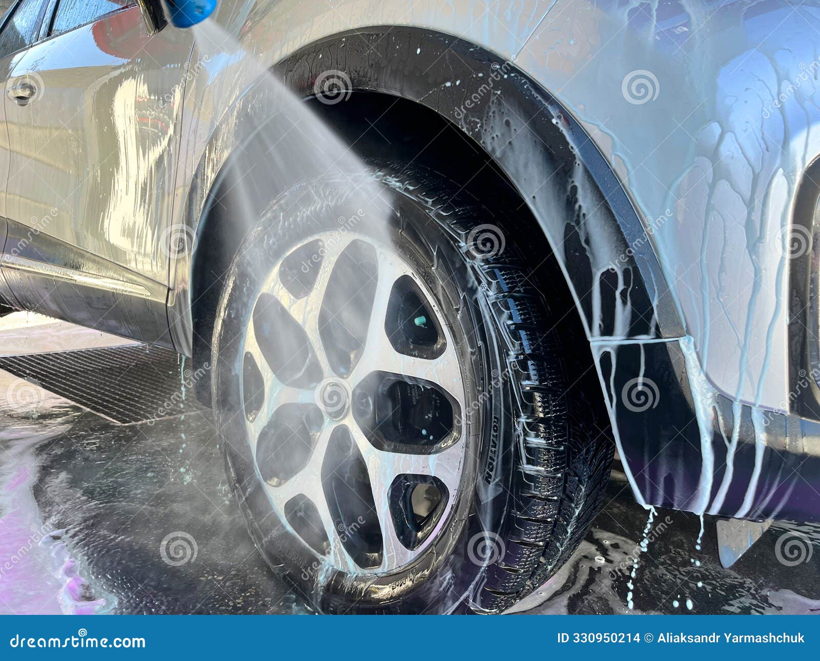 A Silver Car at a Car Wash after Cleaning with Active Foam, Wax is ...