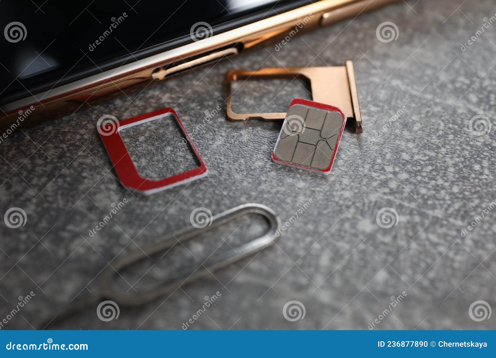 SIM Card, Mobile Phone, Tray and Ejector Tool on Grey Table, Closeup ...