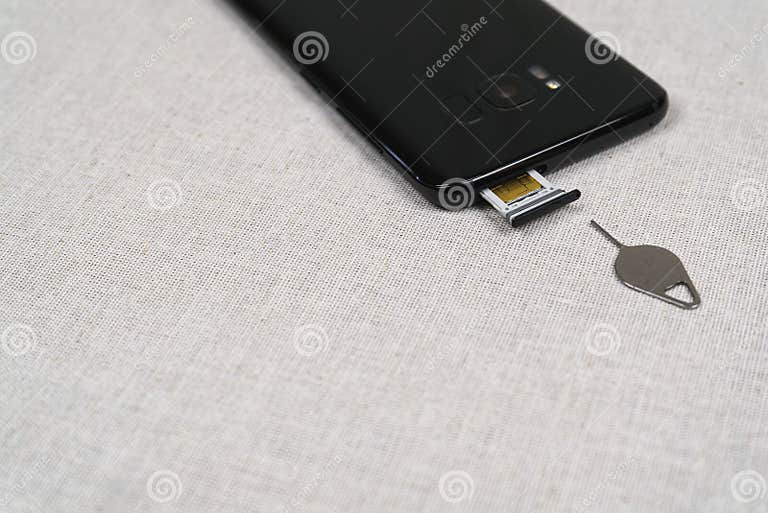 Sim Ejector Tool and SIM Card Slot of Smartphone on Fabric Background ...