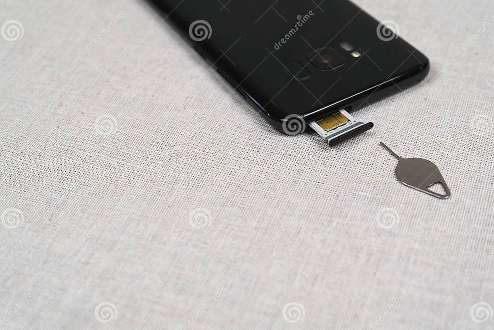 Sim Ejector Tool and SIM Card Slot of Smartphone on Fabric Background ...